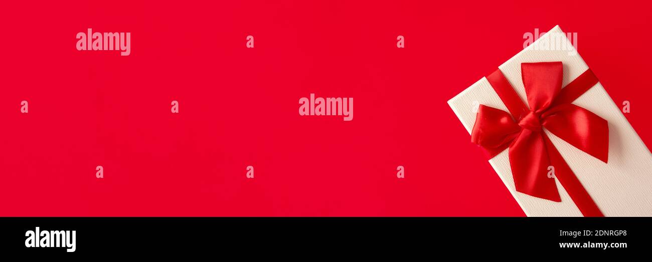 White present with red ribbon on the bright red background Stock Photo ...