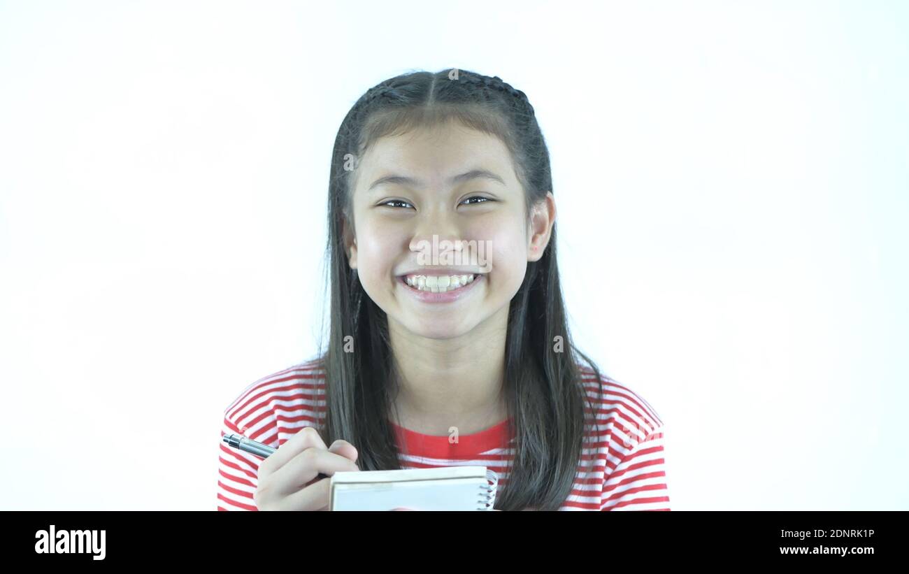 Portrait Of Smiling Girl Writing In Notepad Against White Background ...
