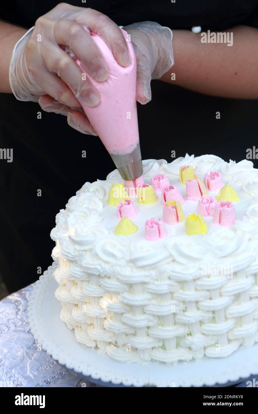 Person decorating cake in a pastry shop Stock Photo - Alamy