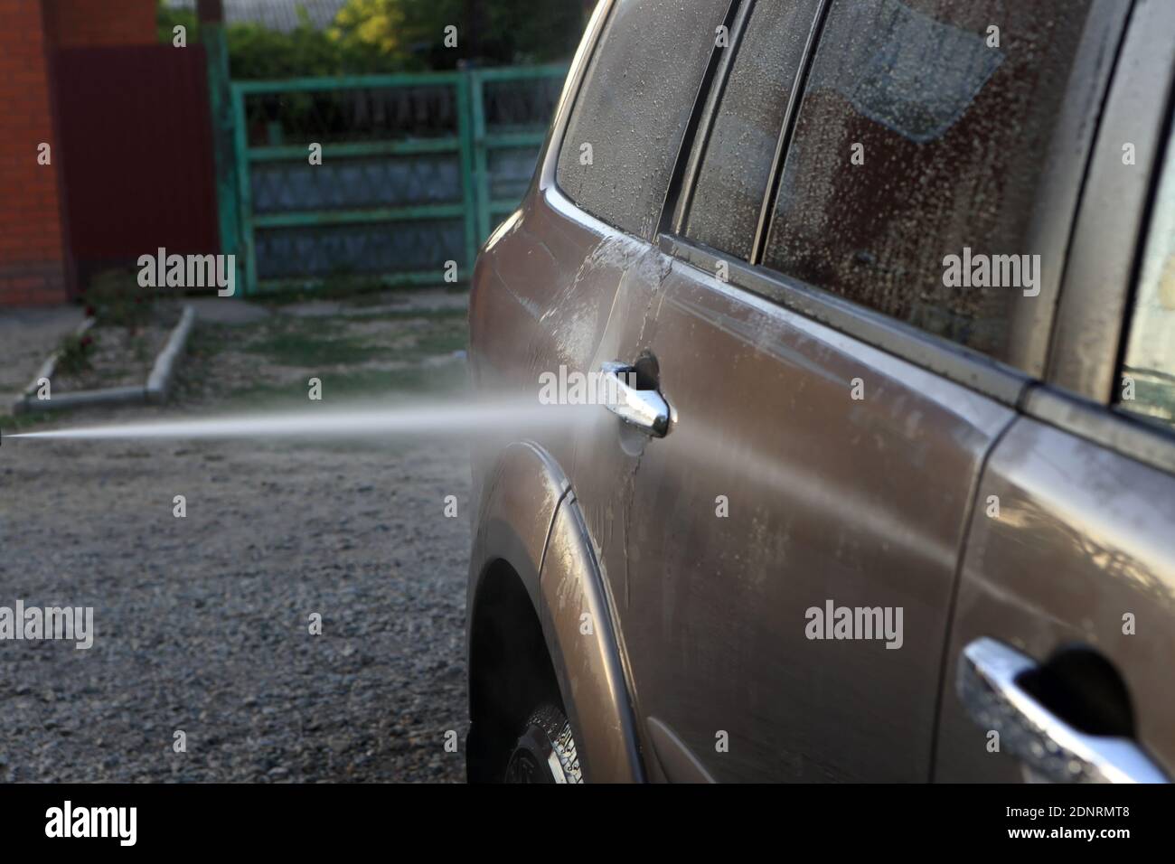 Serviceman washing car with high pressure washer Stock Photo - Alamy