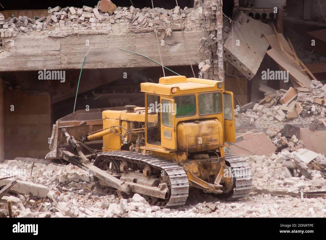 Building demolition. Yellow bulldozer against the background of ...