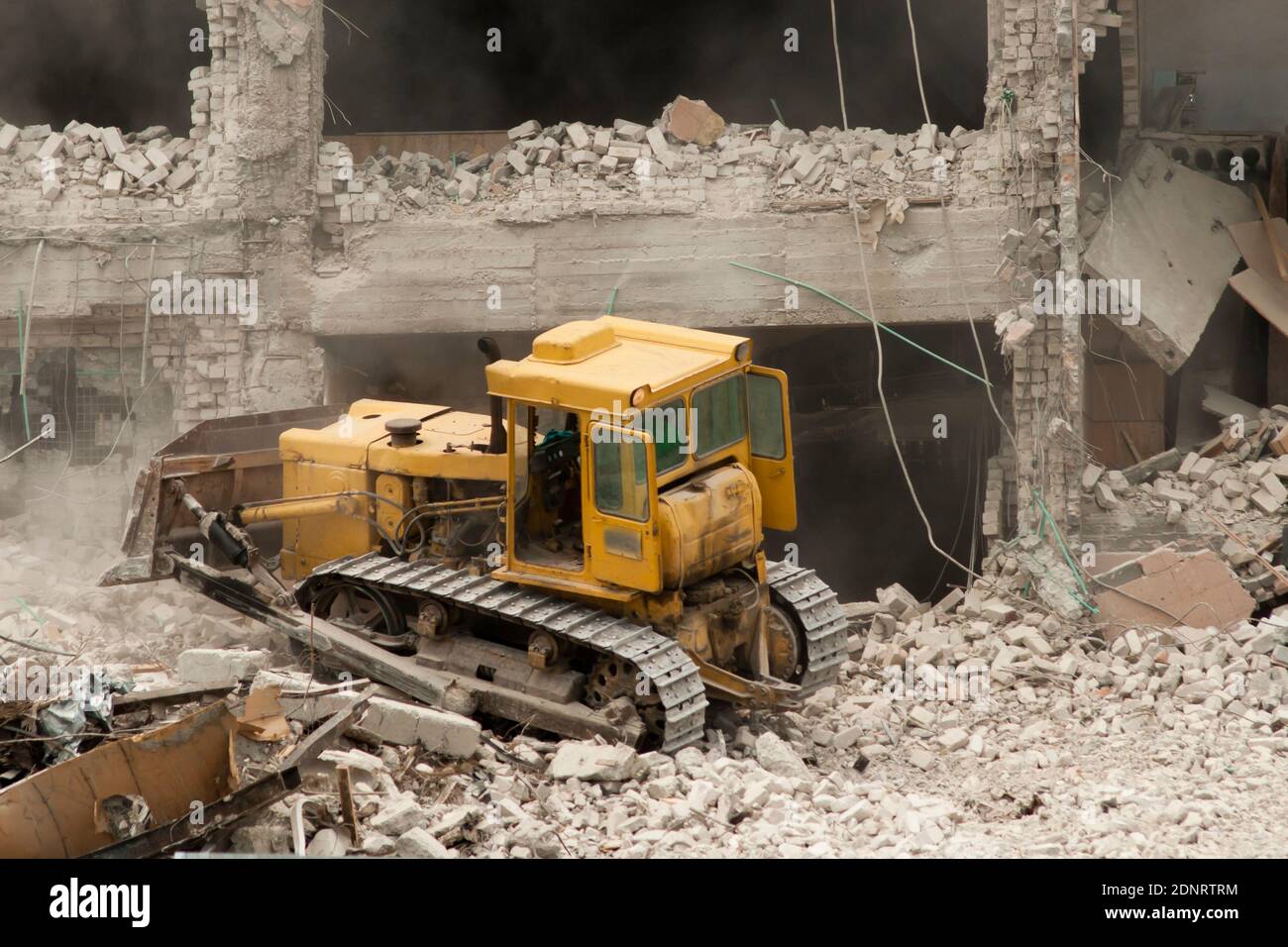 Building demolition. Yellow bulldozer against the background of ...