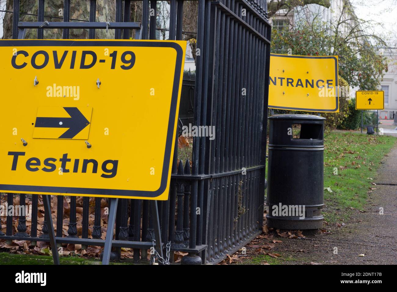 Covid-19 omicron testing signage stand next to cast iron fence pointing ...