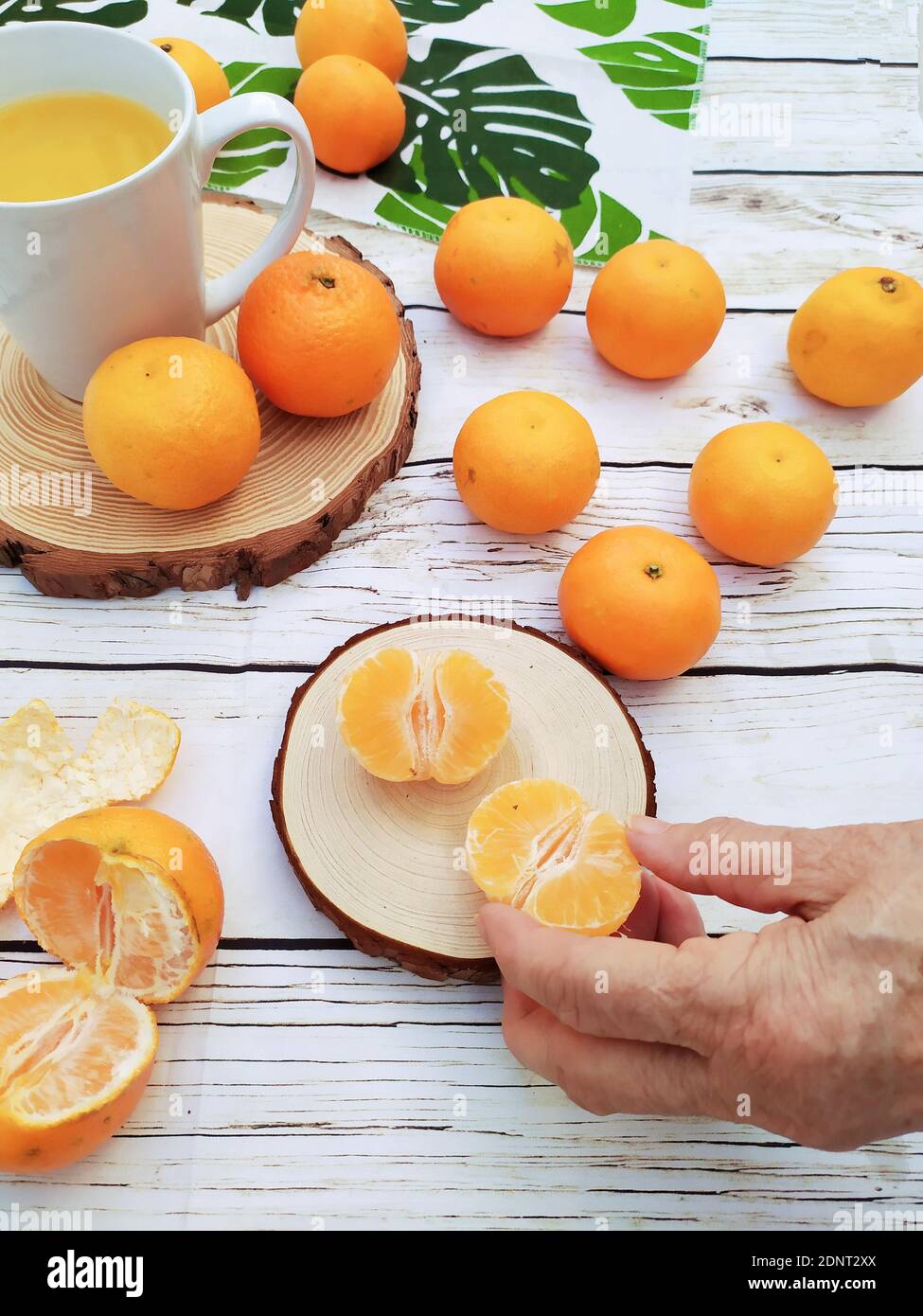 Woman's hand reaching for a satsuma Stock Photo - Alamy