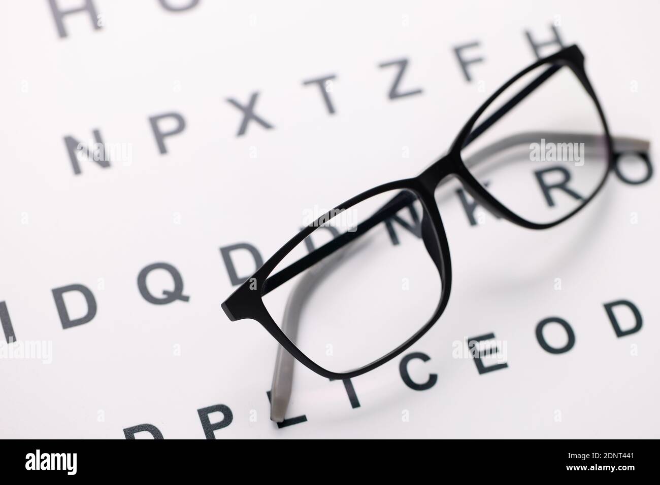 Glasses for vision in black frames lying on test chart closeup Stock ...