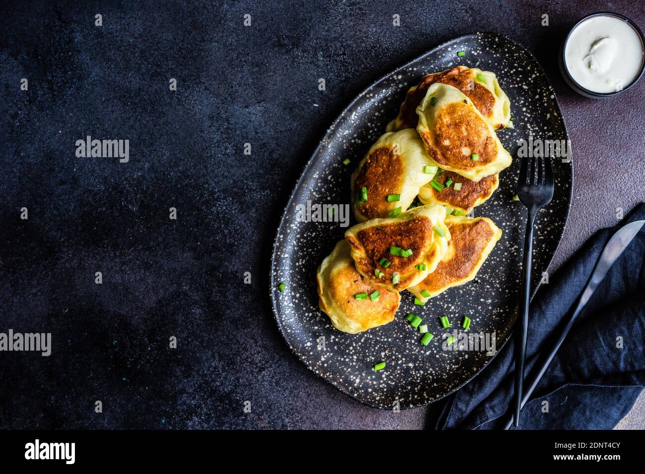 Ukrainian vareniki potato dumplings with chive garnish and sour cream ...