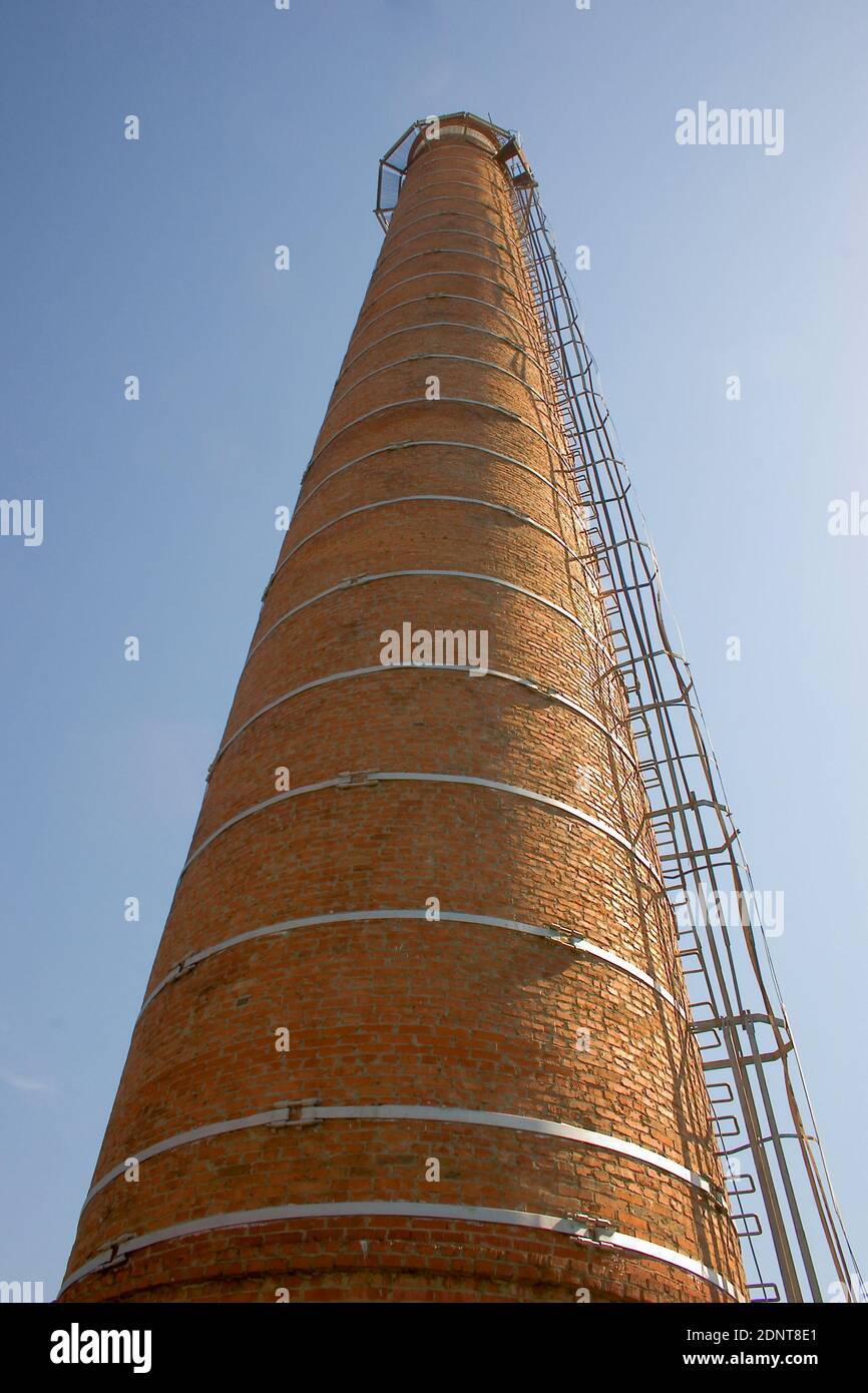 Stairway to Heaven. High brick industrial chimney and staircase with a ...