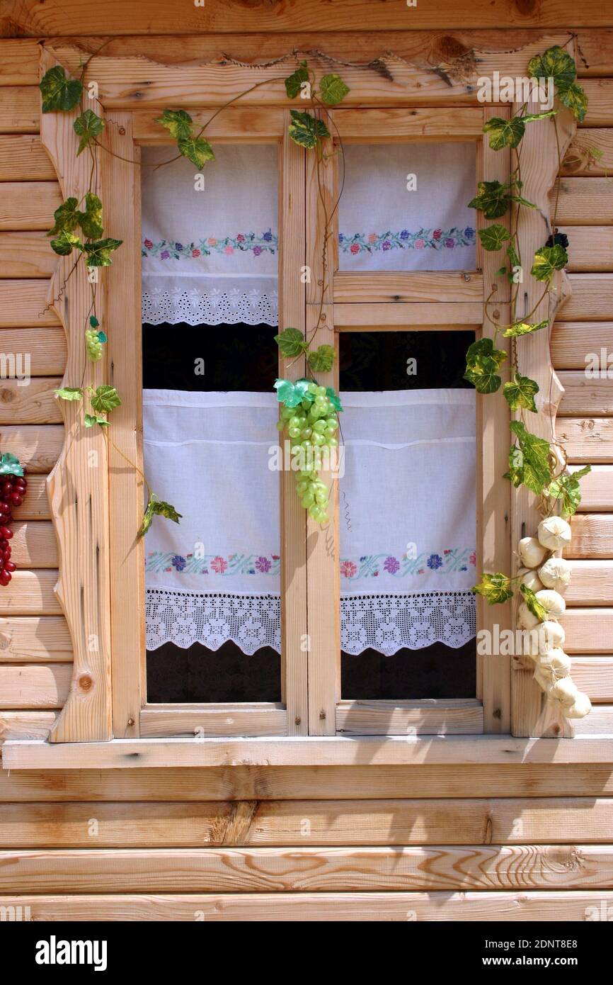 Window. Outside view. Wooden window in a wooden wall with curtains and ...