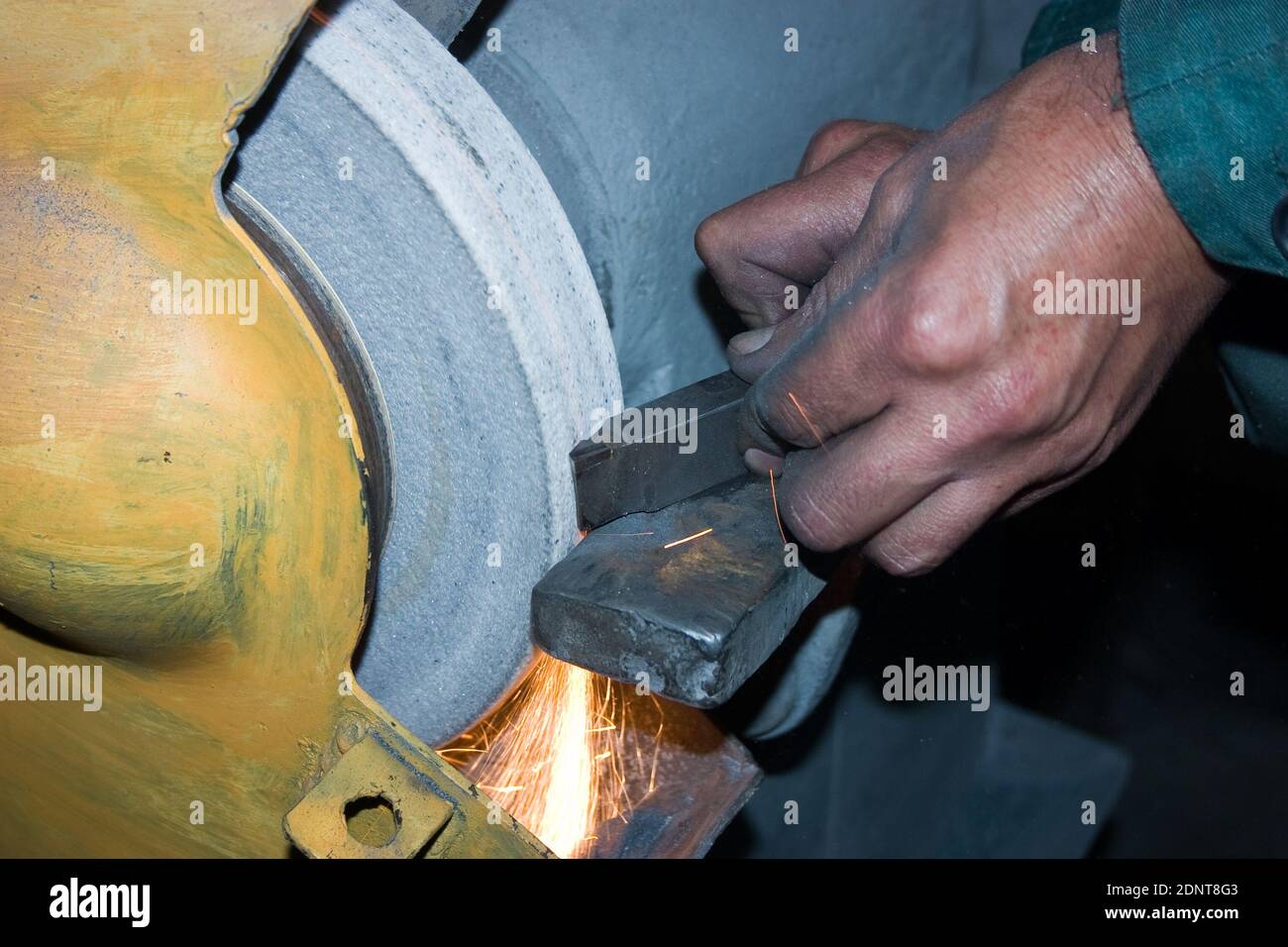 Sharpening a turning tool. Worker's hands are grinding a turning tool ...