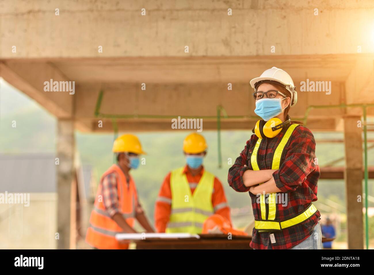 Three engineers on a building site wearing face masks, Thailand Stock ...