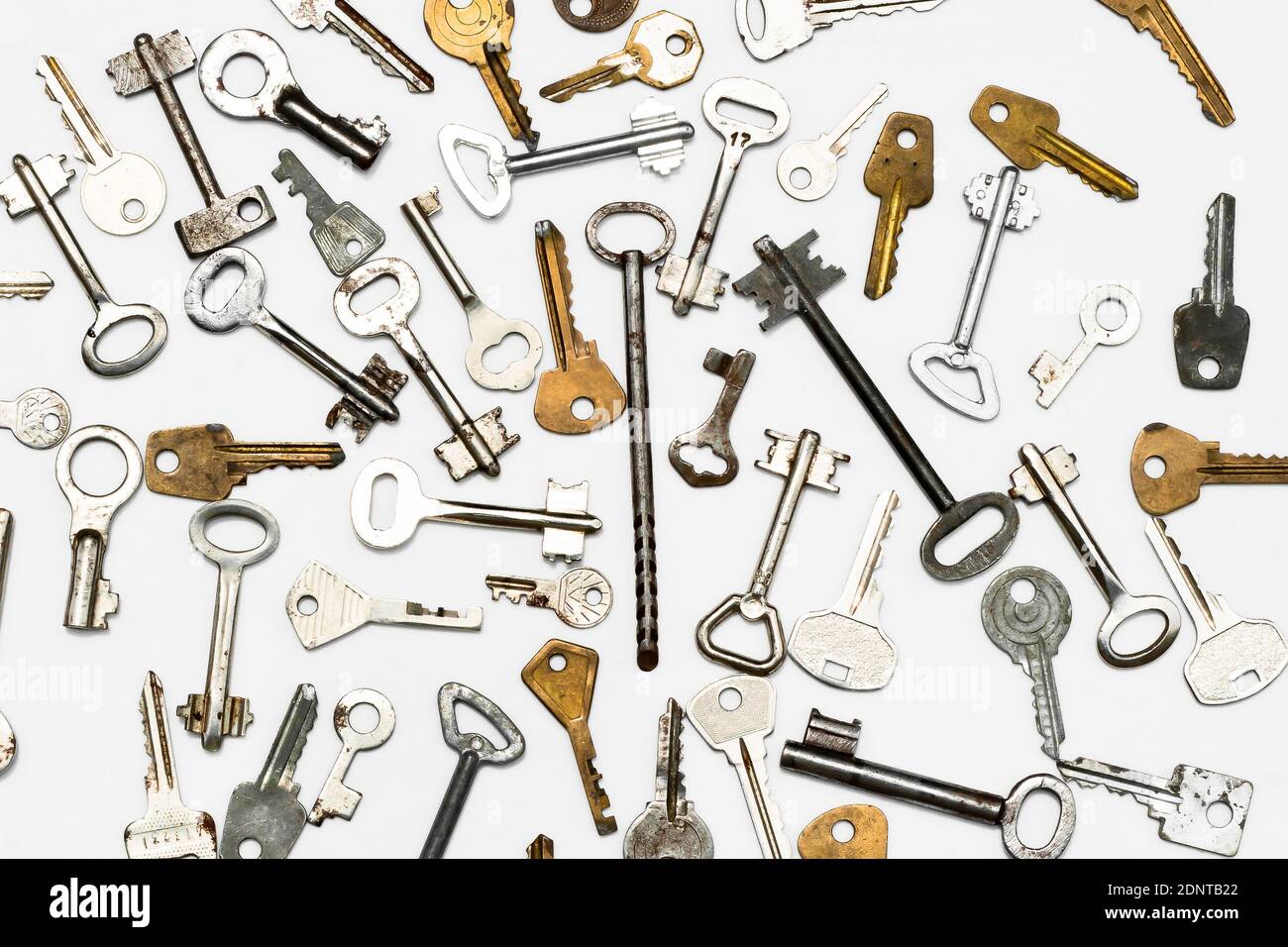 Keys to the locks. Many different keys to the locks lie on a white ...