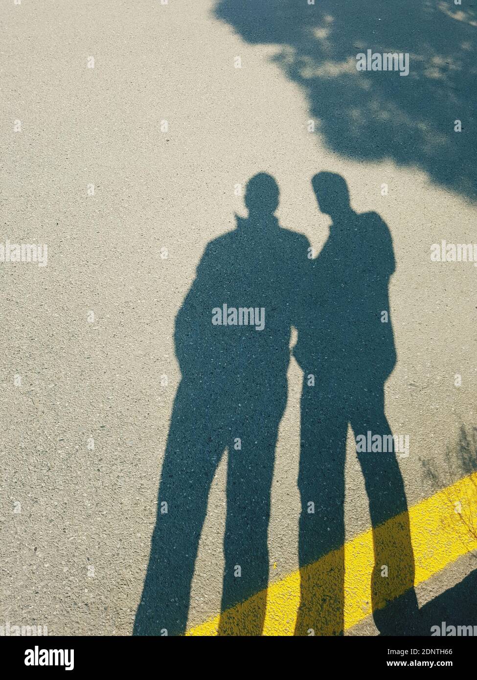 Shadow Of Men On Road Stock Photo - Alamy