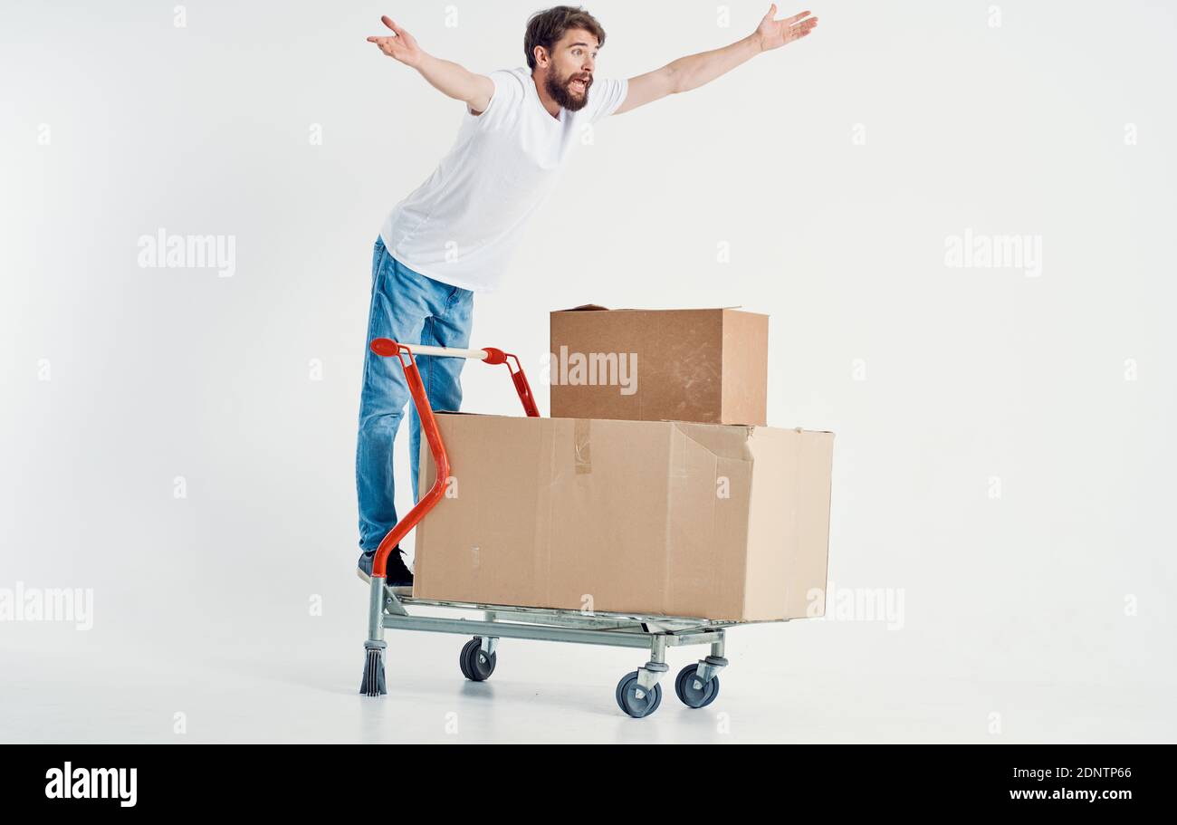 cardboard boxes on a cargo trolley and happy men gesturing with hands ...