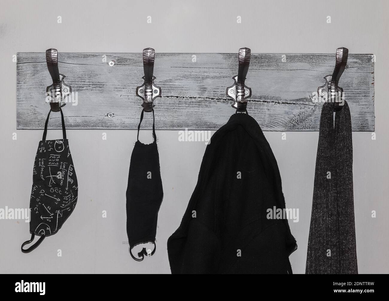 Black corona face masks hanging at a wooden wardrobe. Pandemic virus ...