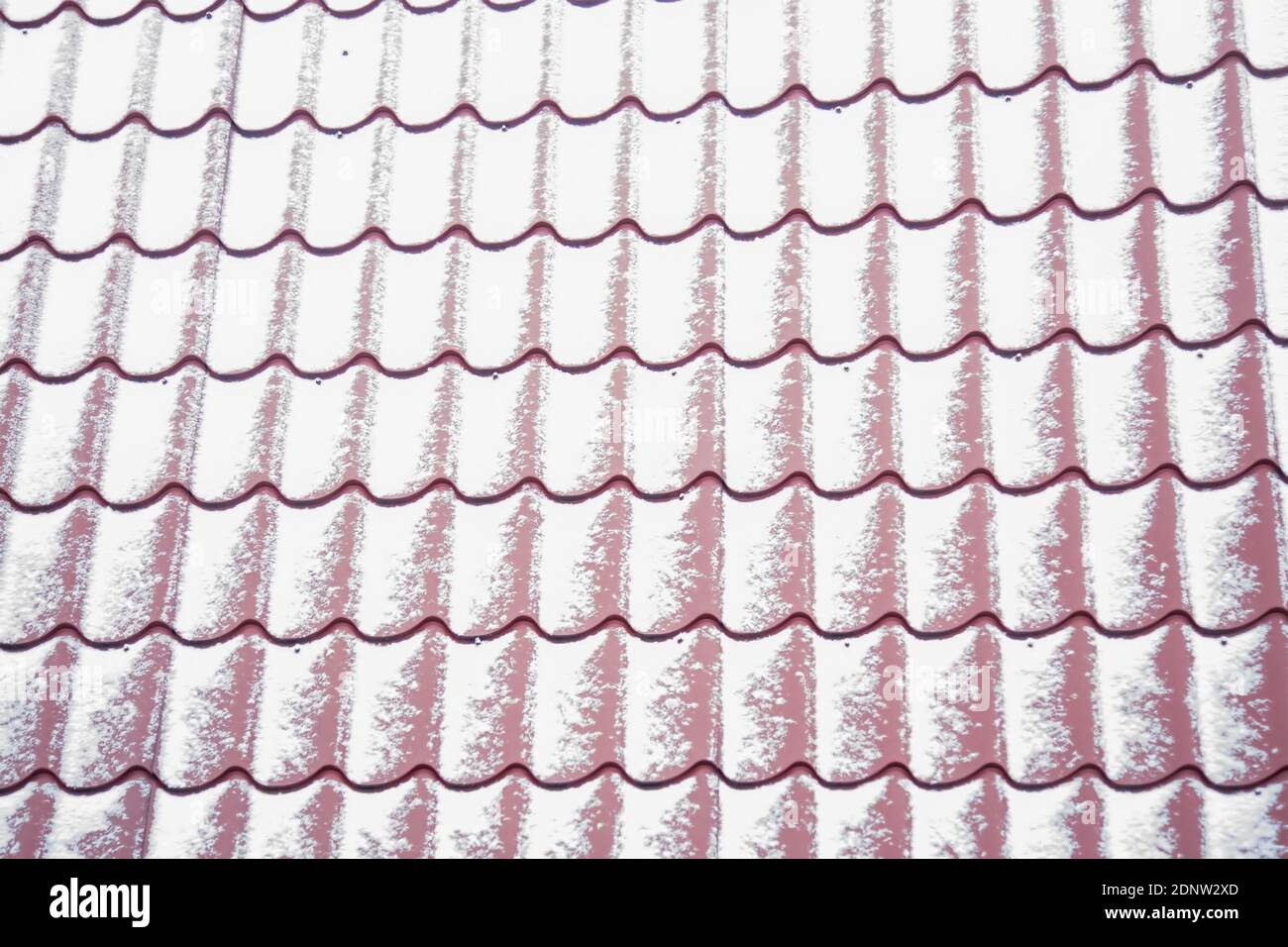 texture closeup red metal roof tile covered with a thin layer of snow ...
