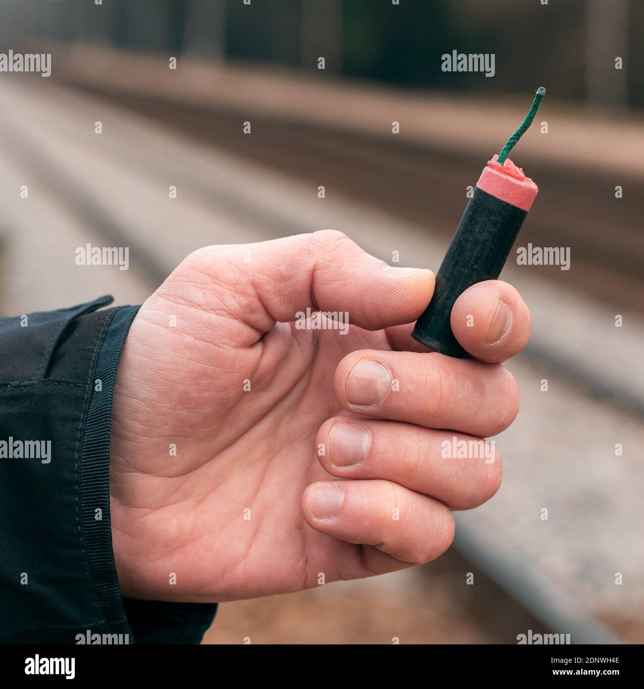 The Firecracker in a Hand. Man Holding a Black Petard in His Hand. A ...