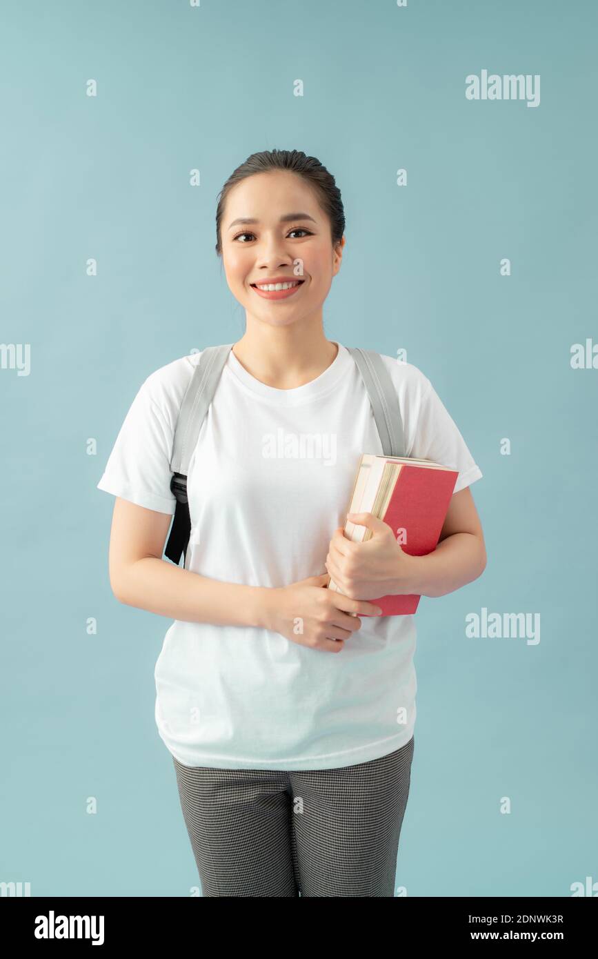 Portrait of a smiling asian student girl wearing backpack and holding ...