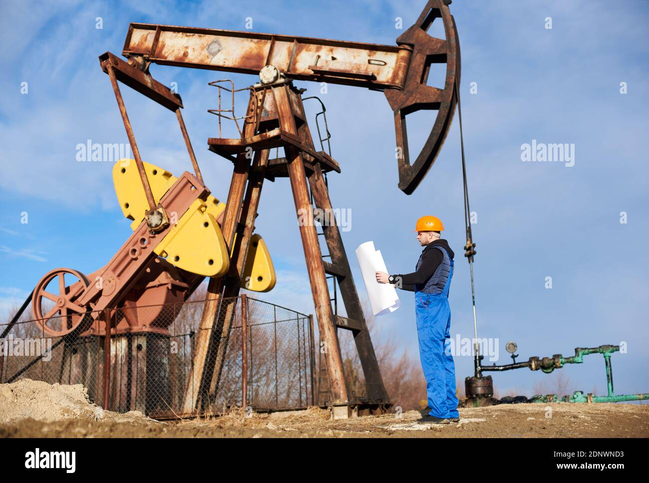 Full length of oil man holding placard with oil field plan. Male worker ...