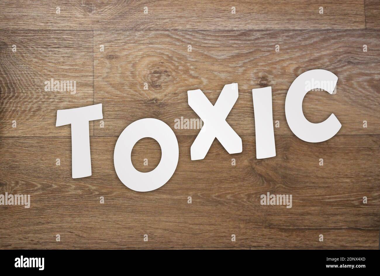 TOXIC word is put by white alphabet letters on wooden table. Medical ...