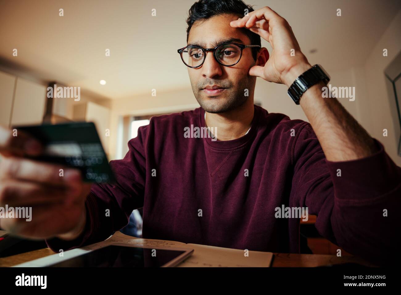 Stressed mixed race business man attempting to make online payments ...
