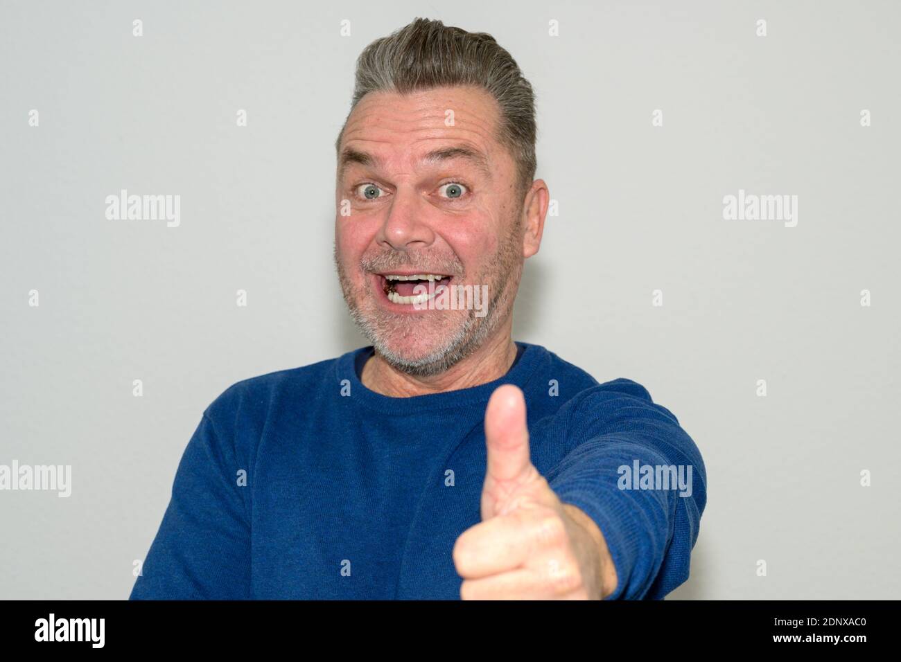 Excited enthusiastic man in his 50s giving a thumbs up gesture with a ...