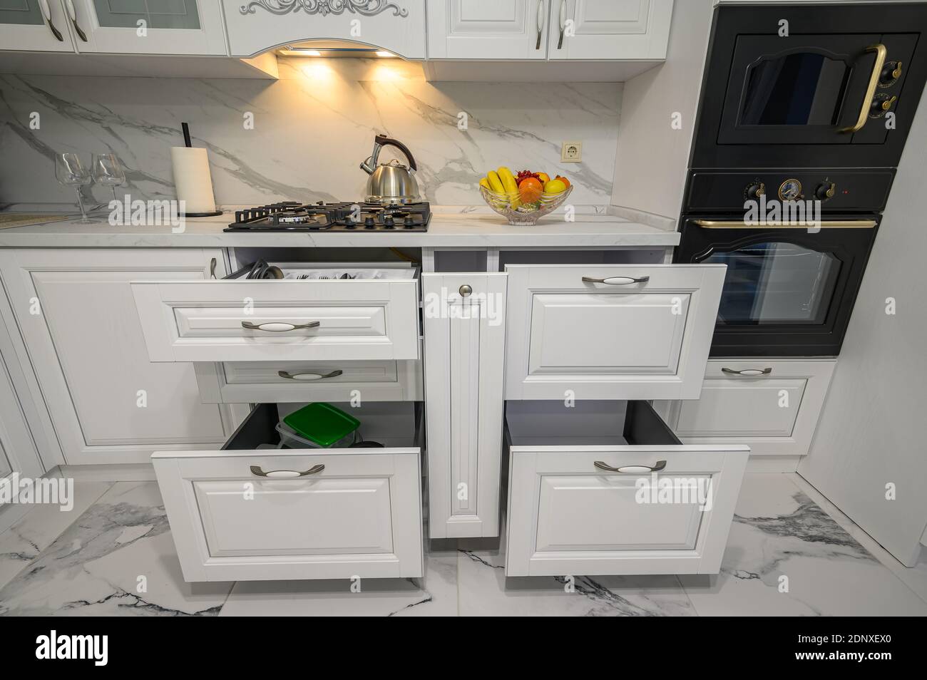 Open drawers with kitchenware at modern white kitchen Stock Photo - Alamy