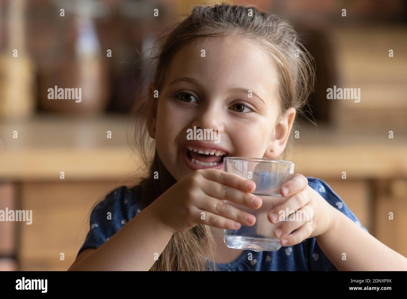 Happy little girl feeling glad drinking cool water from glass Stock ...