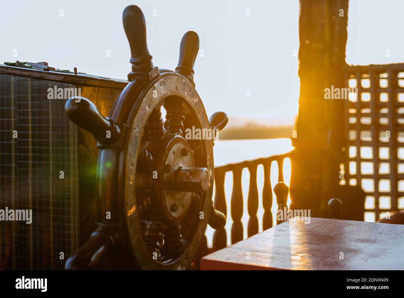 Wooden Helm or steering wheel of a shipping vessel with a sunrise in ...