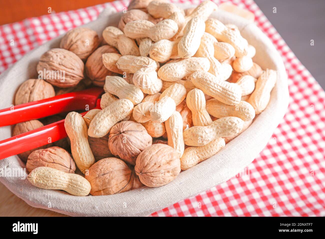 Mixed of nuts, hazelnuts and dried peanuts with nutcracker on wooden ...