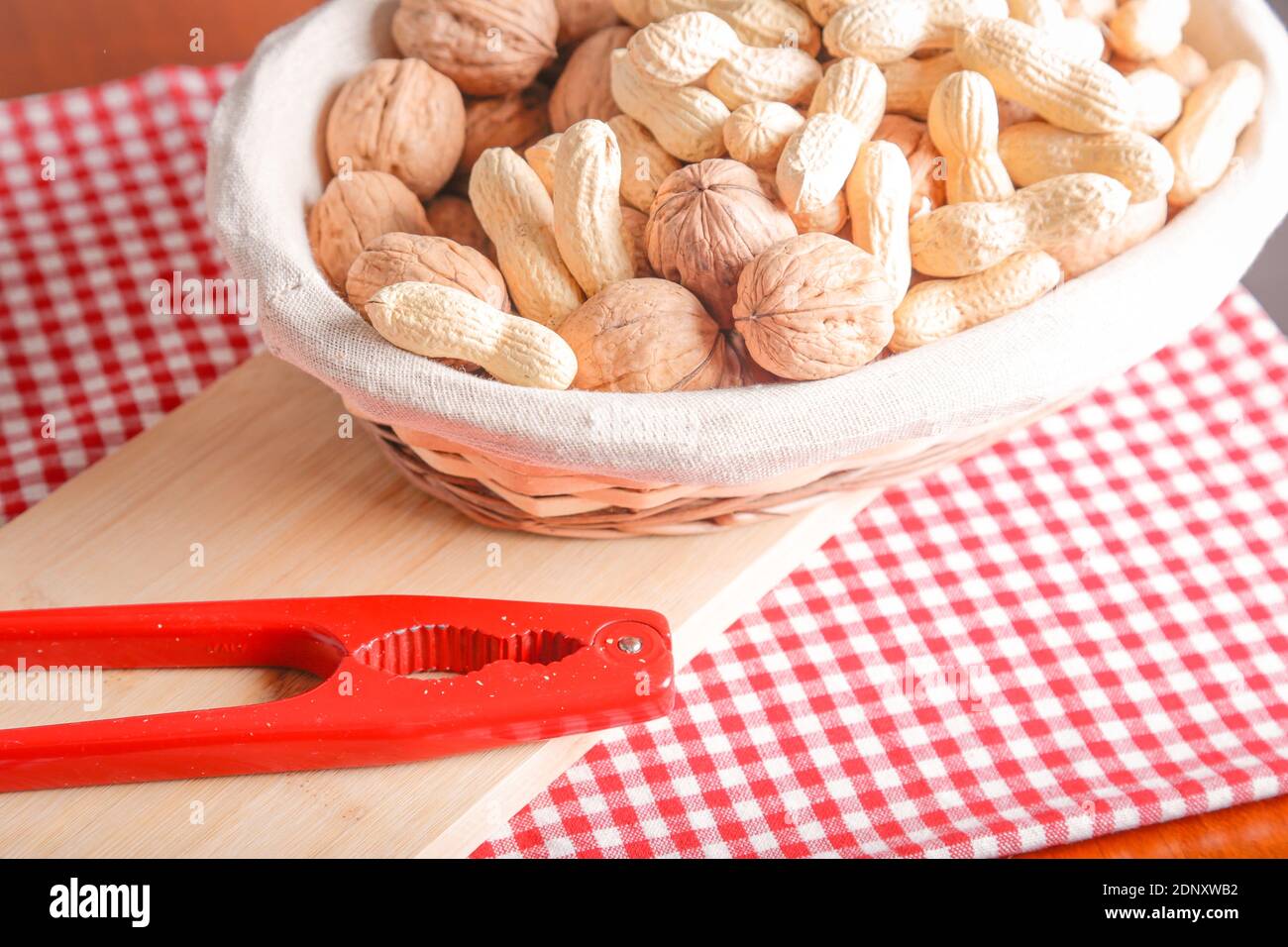 Mixed of nuts, hazelnuts and dried peanuts with nutcracker on wooden ...