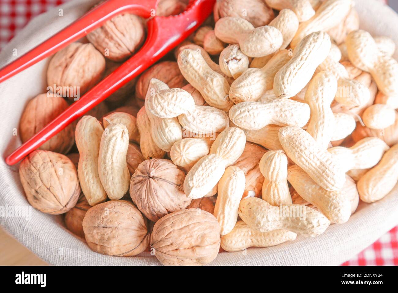 Mixed of nuts, hazelnuts and dried peanuts with nutcracker on wooden ...