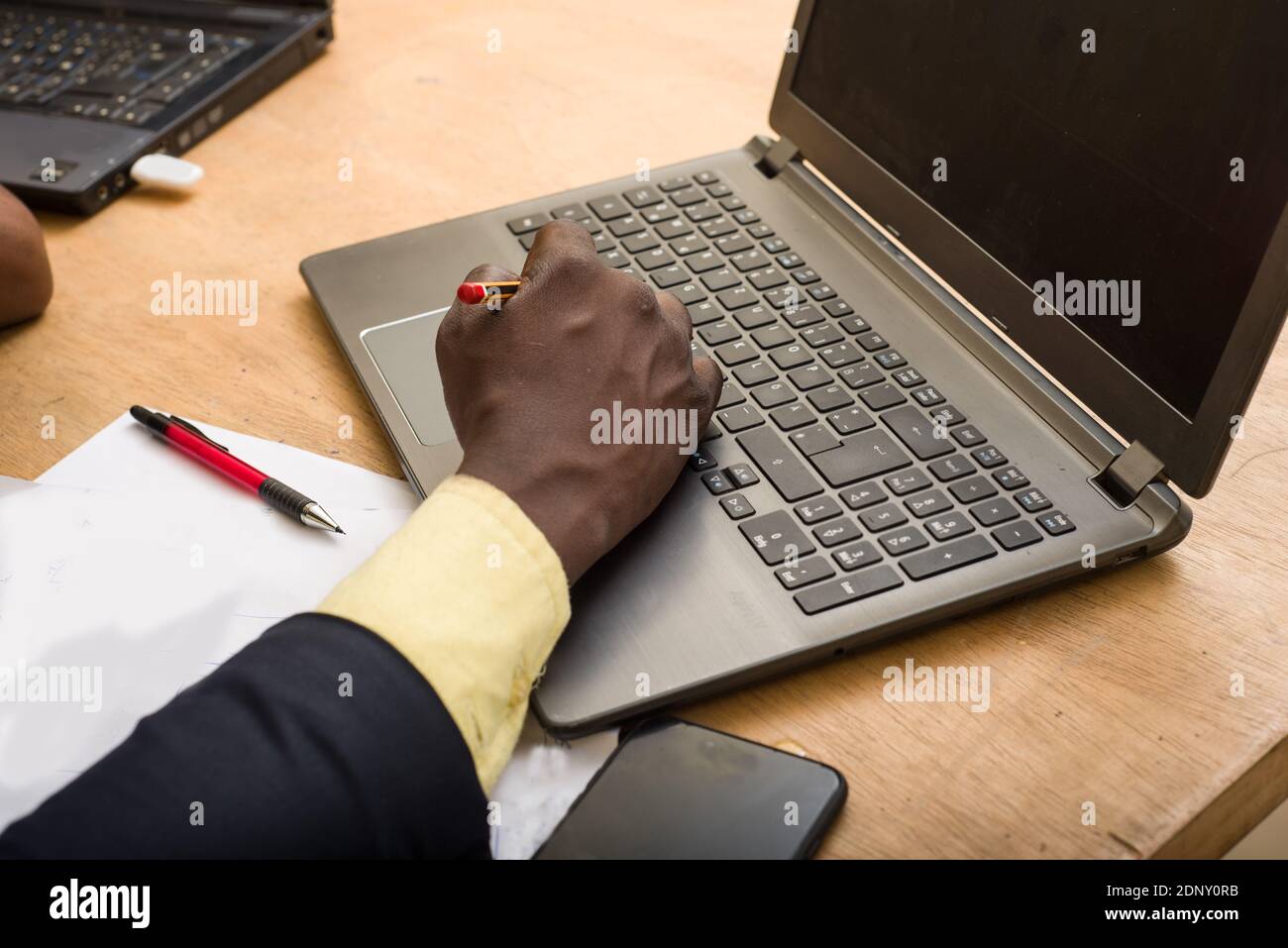 close-up of a businessman's hand resting on a desk on computer keyboard ...