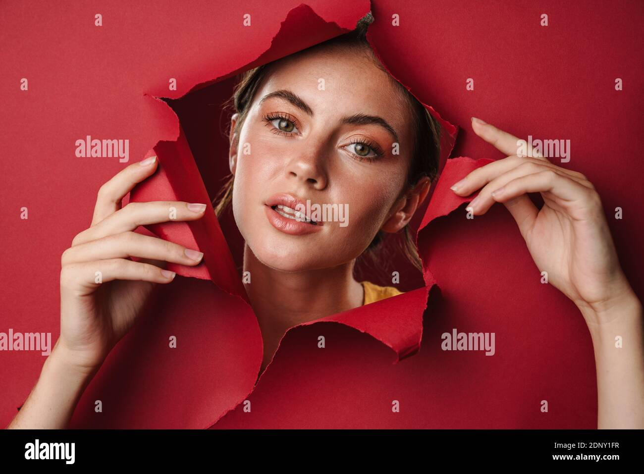 Smiling girl peeping through hole in paper isolated Stock Photo - Alamy