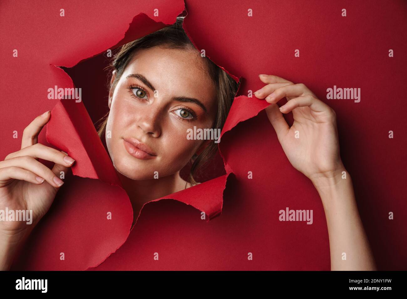 Smiling girl peeping through hole in paper isolated Stock Photo - Alamy