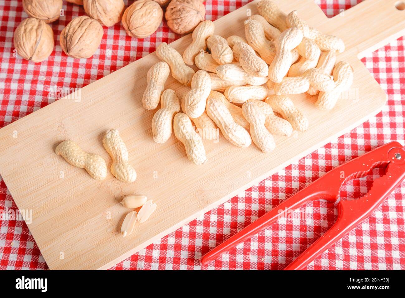 Mixed of nuts, hazelnuts and dried peanuts with nutcracker on wooden ...