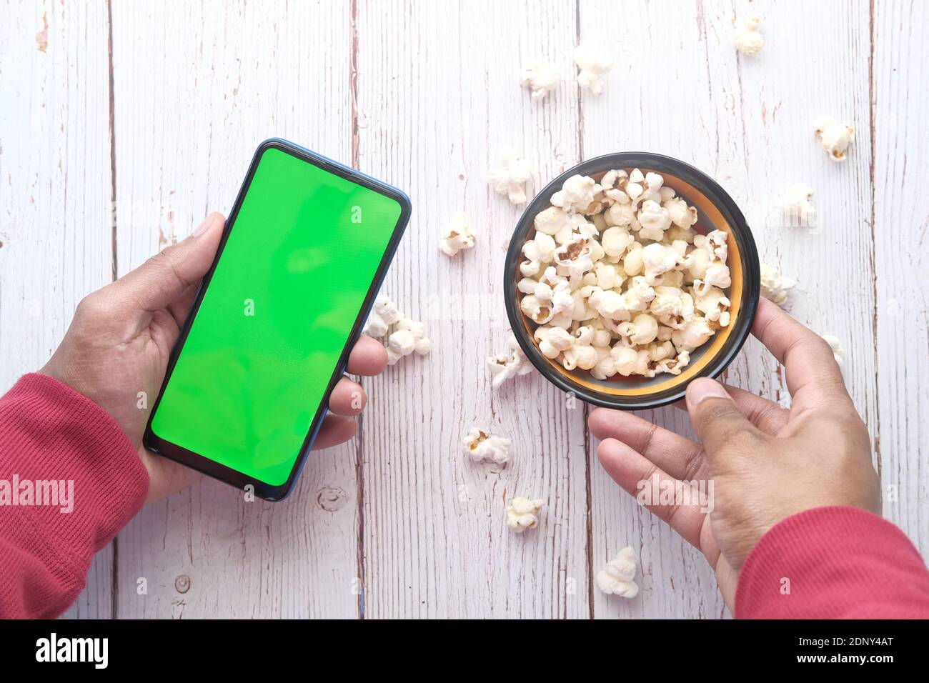 man hand using smart phone and eating popcorn Stock Photo - Alamy