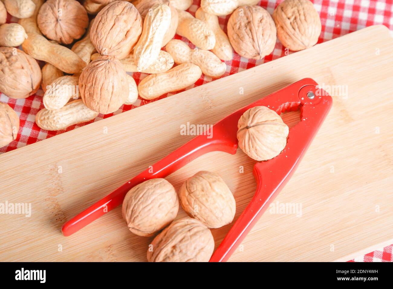 Mixed of nuts, hazelnuts and dried peanuts with nutcracker on wooden ...