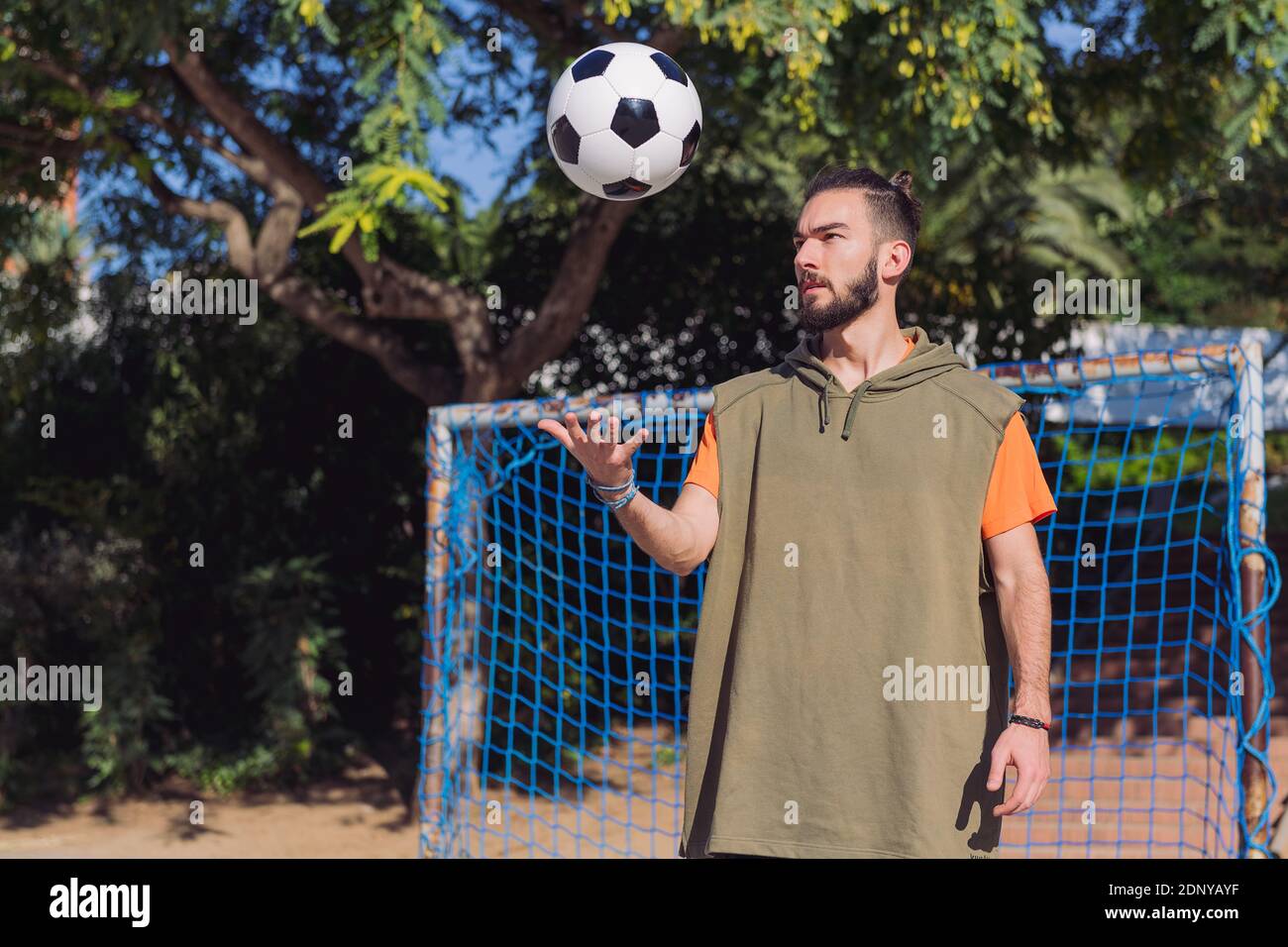 handsome hipster football player in front of the goal of an urban court ...