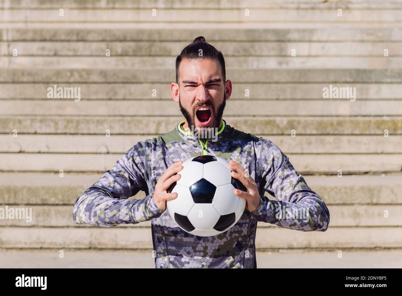 horizontal portrait of a handsome sportsman screaming in a concrete ...