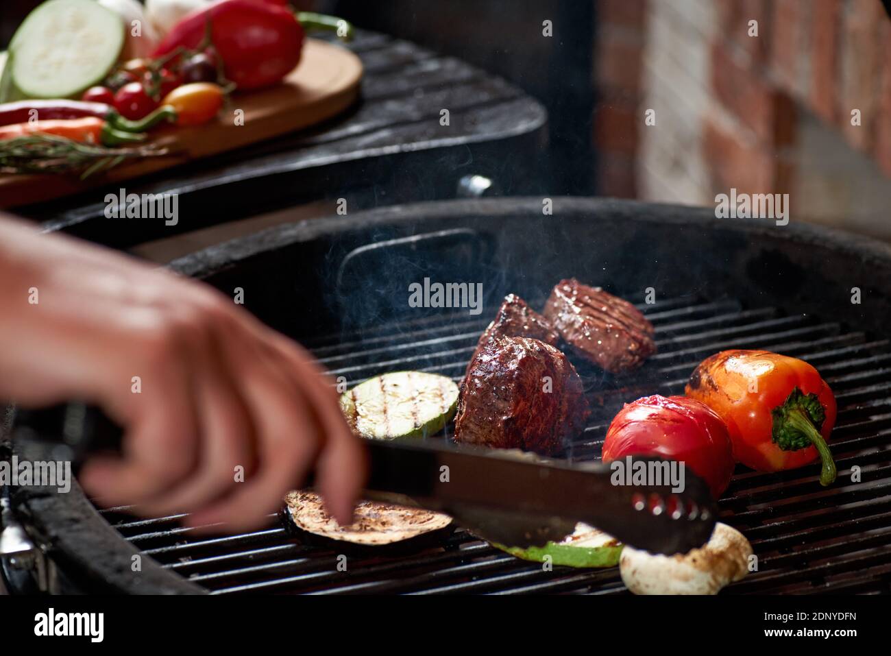 BBQ cooking concept, vegetables and meat sizzling on the grill with ...