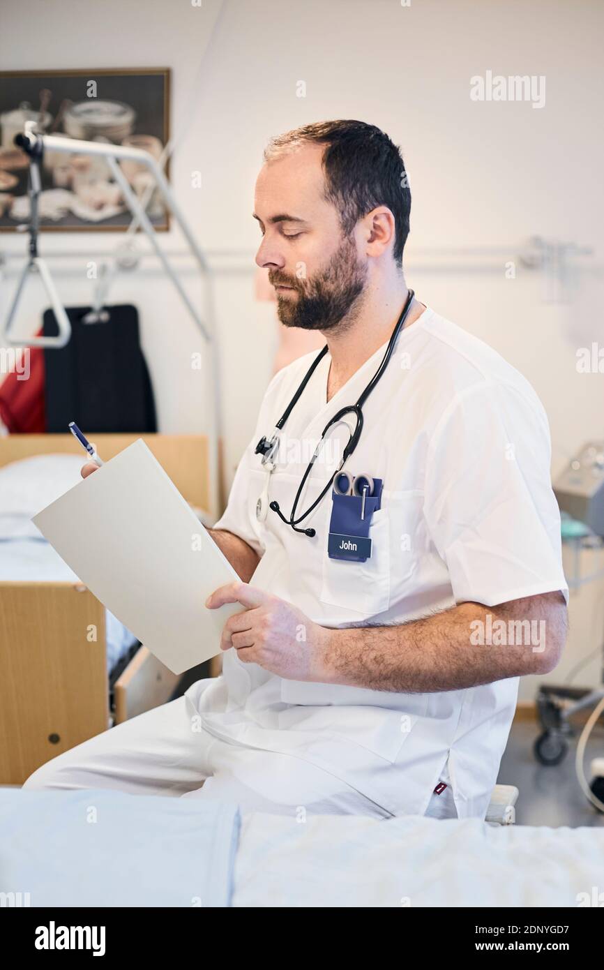 Doctor reading medical records in office Stock Photo - Alamy