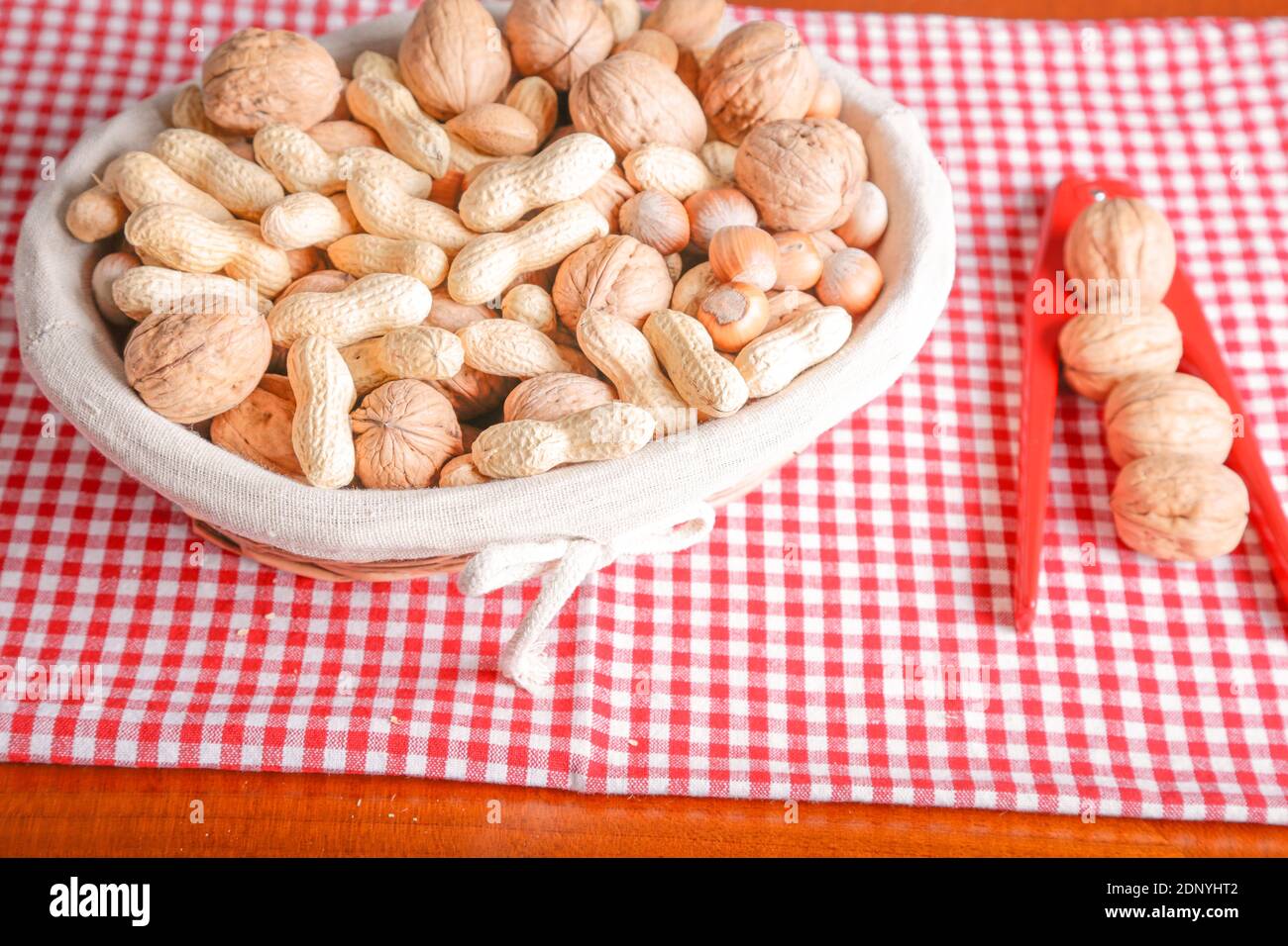 Mixed of nuts, hazelnuts and dried peanuts with nutcracker on wooden ...