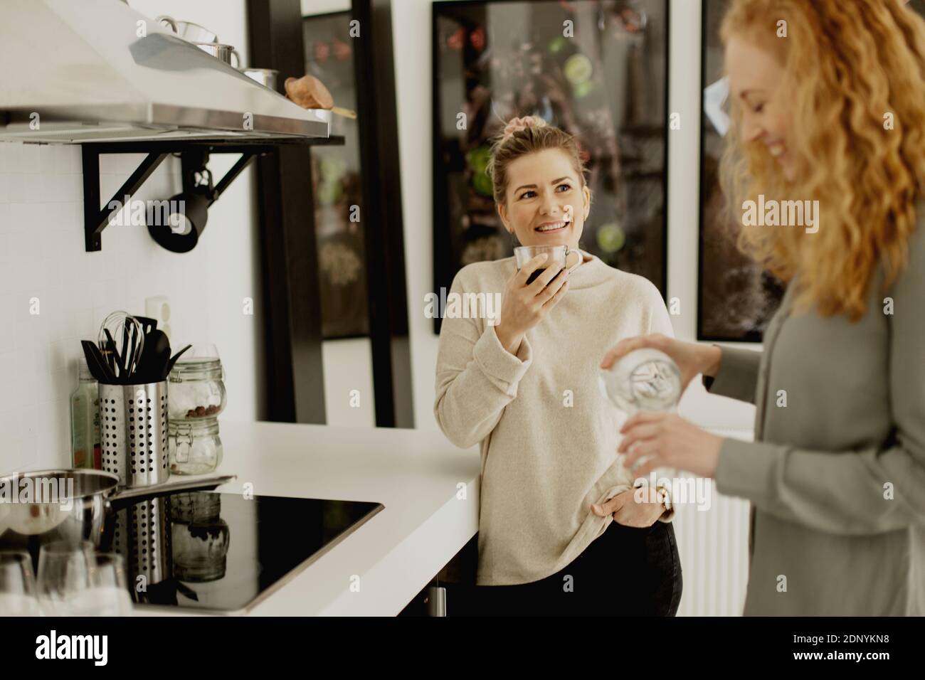 Smiling women talking in kitchen Stock Photo - Alamy
