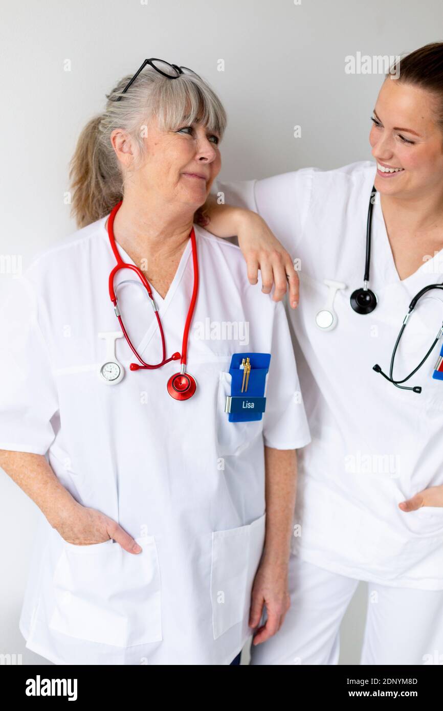 Smiling female doctors talking Stock Photo - Alamy