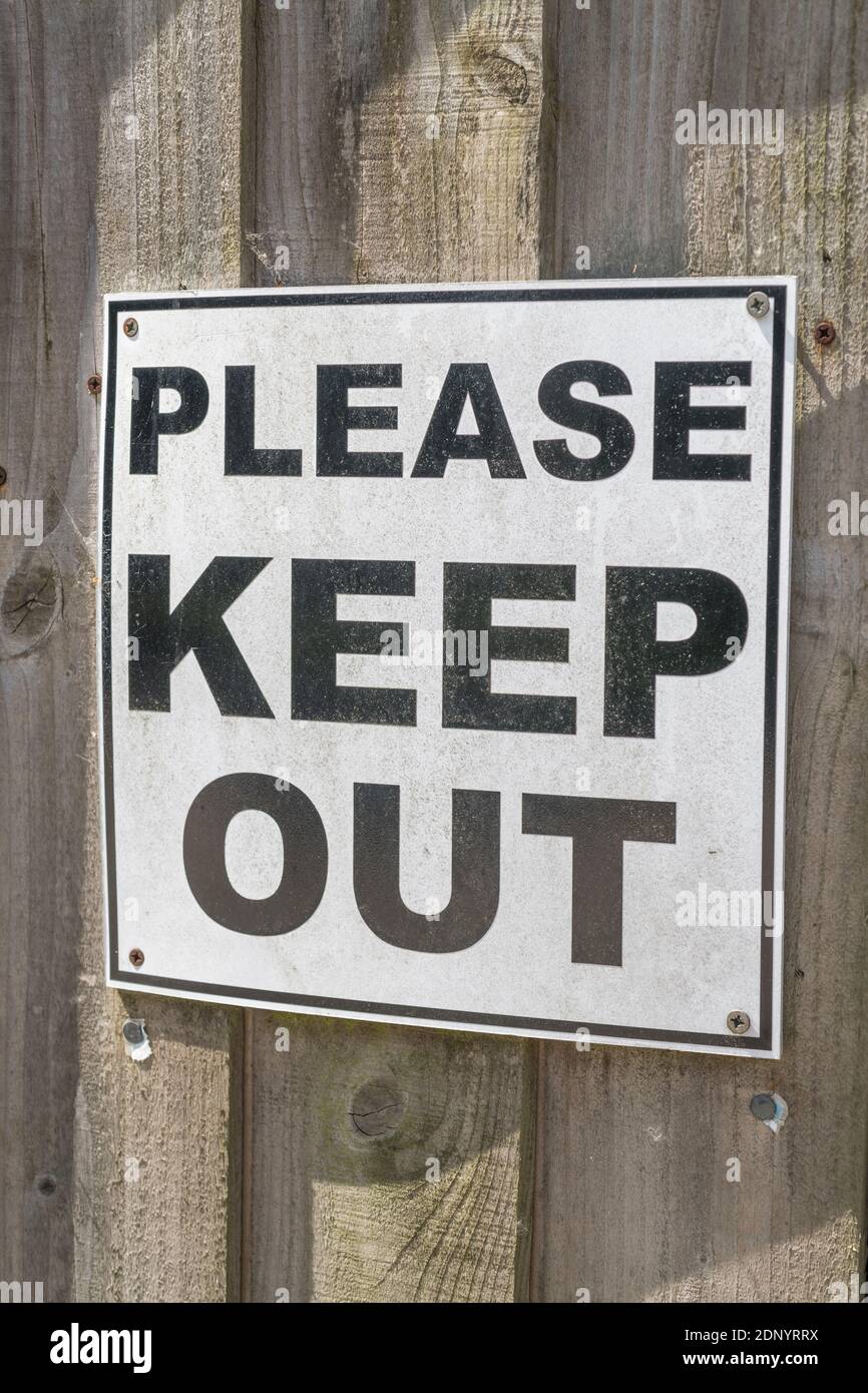 'Please Keep Out' sign on wooden fence in sunshine. No access concept ...