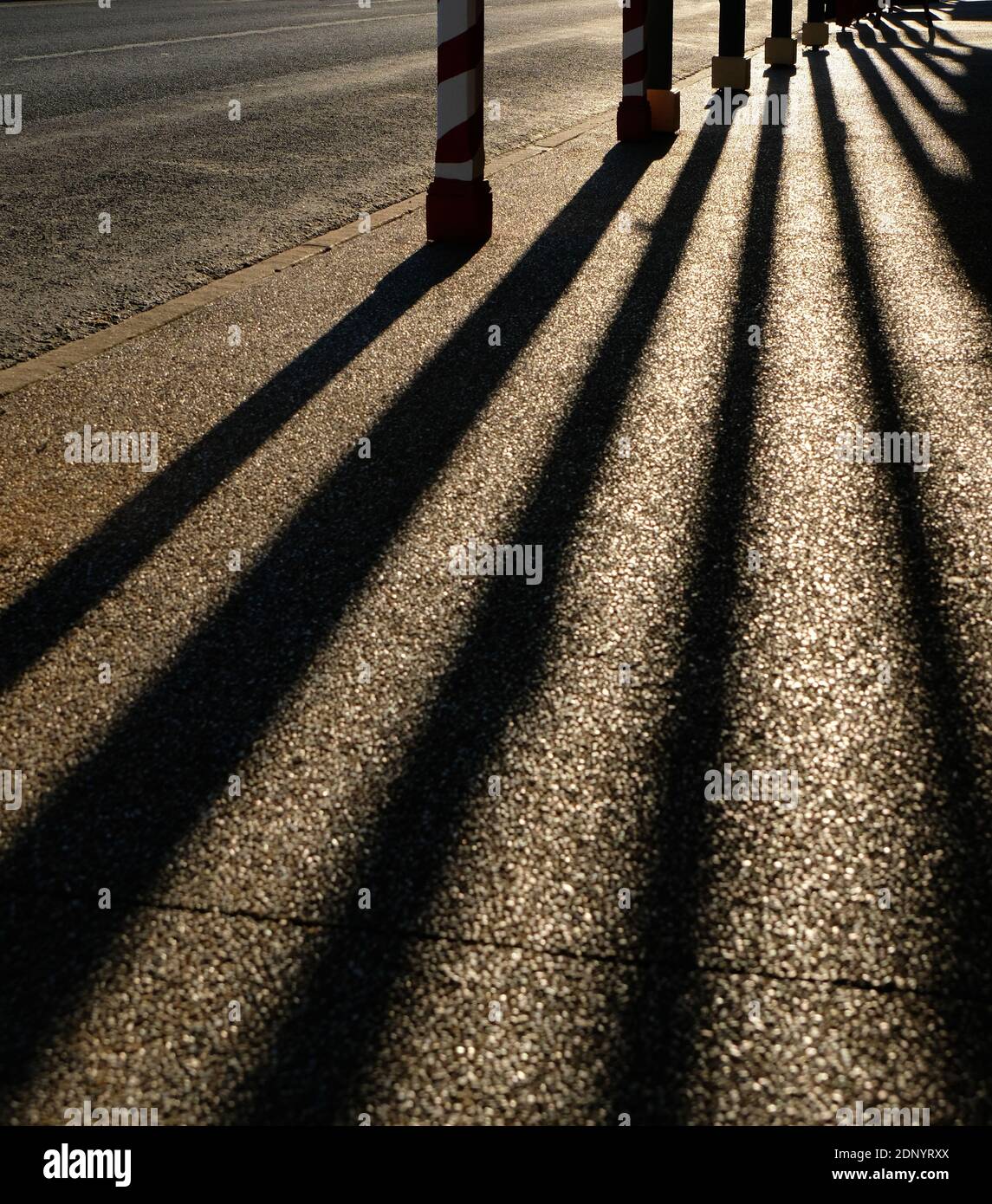 Shadow Of Bollards On Sidewalk In City During Sunset Stock Photo - Alamy