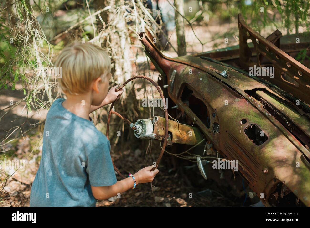 Boy playing in wrecked car Stock Photo - Alamy