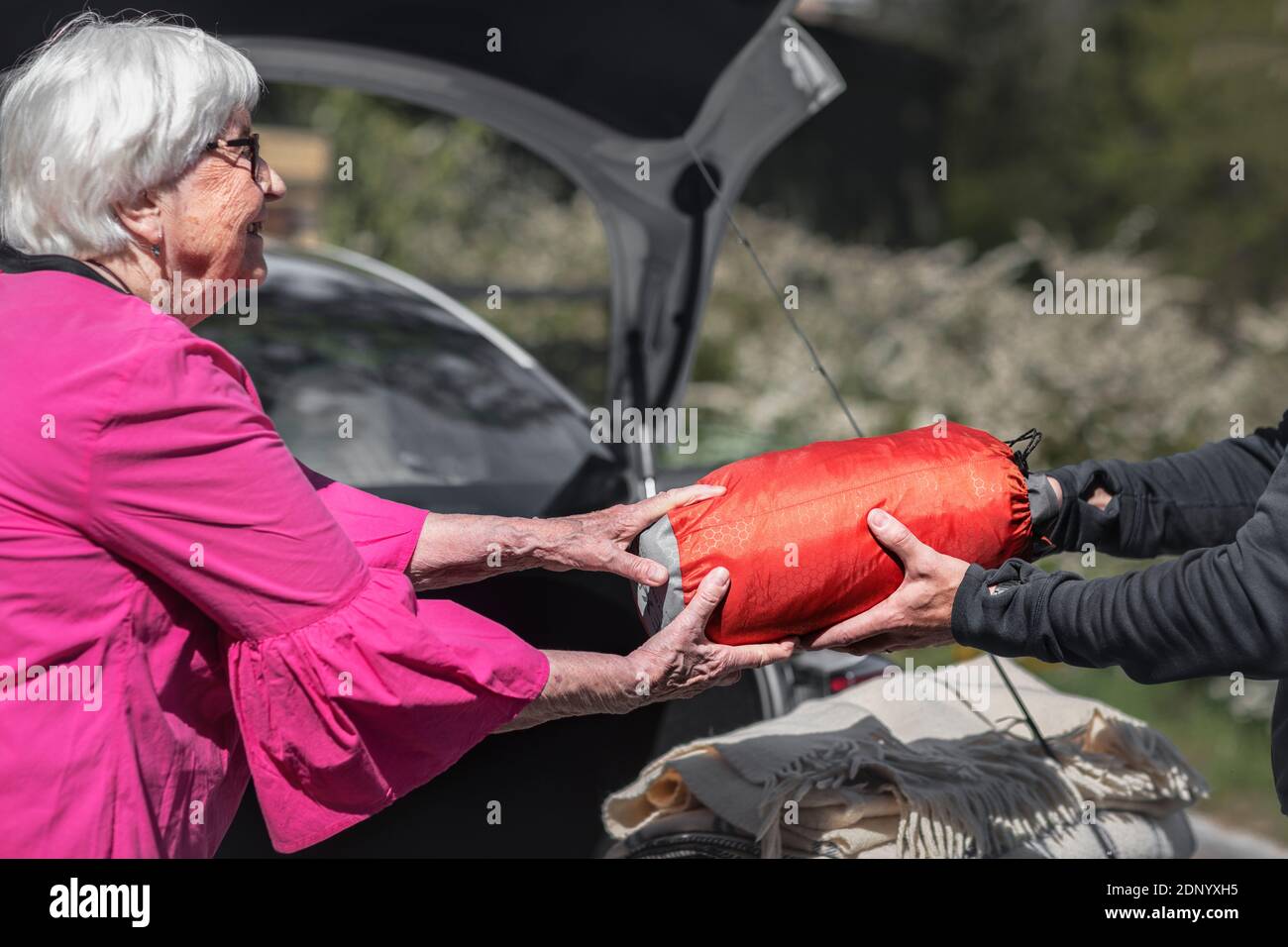 Senior woman loading car Stock Photo - Alamy