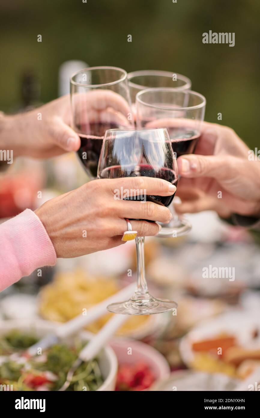 People clinking red wine glasses Stock Photo - Alamy