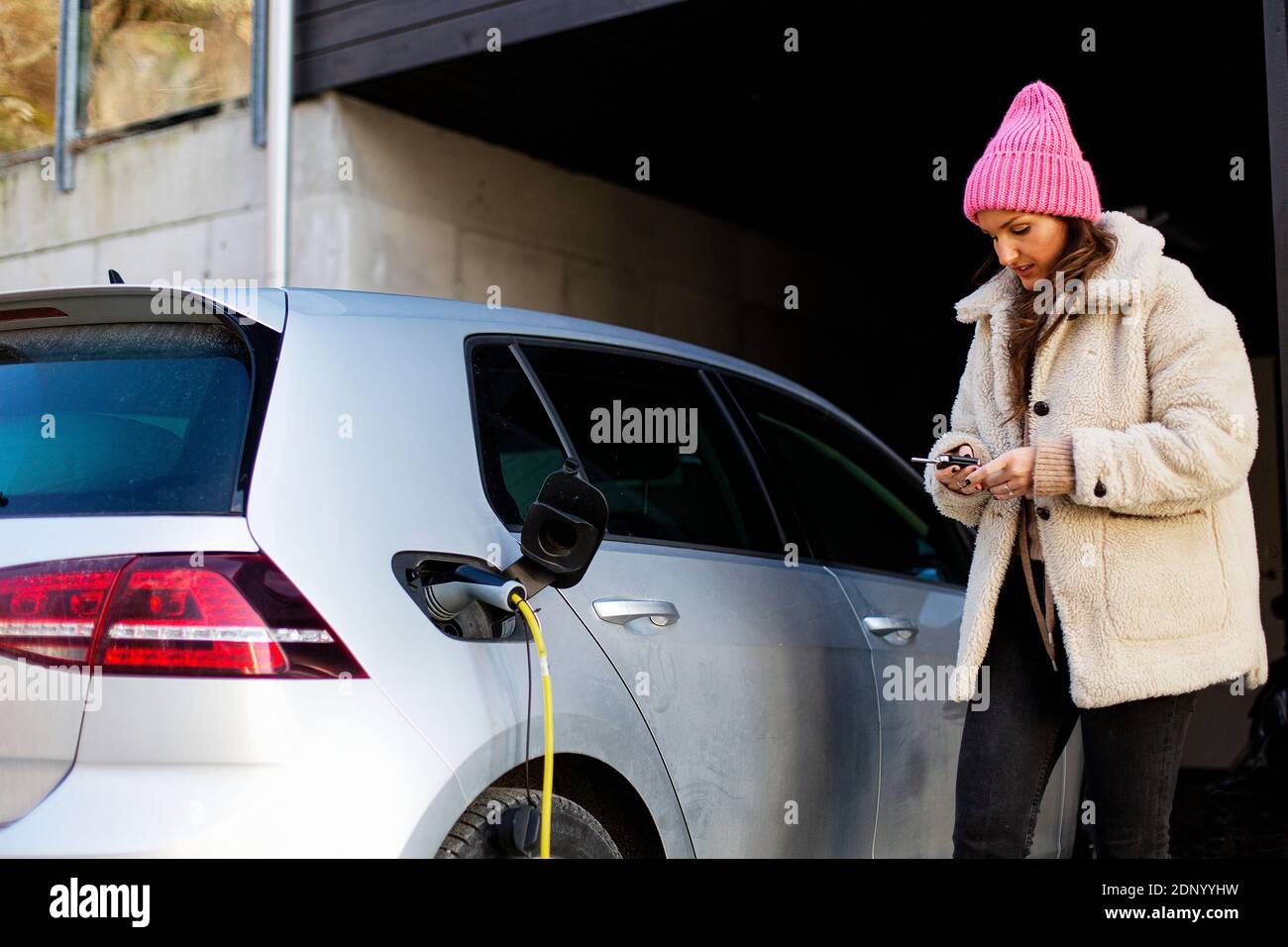 Woman charging electric car Stock Photo - Alamy